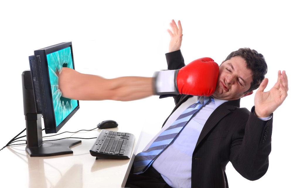 Business man with computer hit by boxing glove in stress concept ...